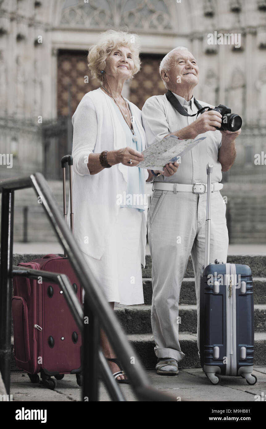Happy positive smiling mature couple making photo and using map during ...
