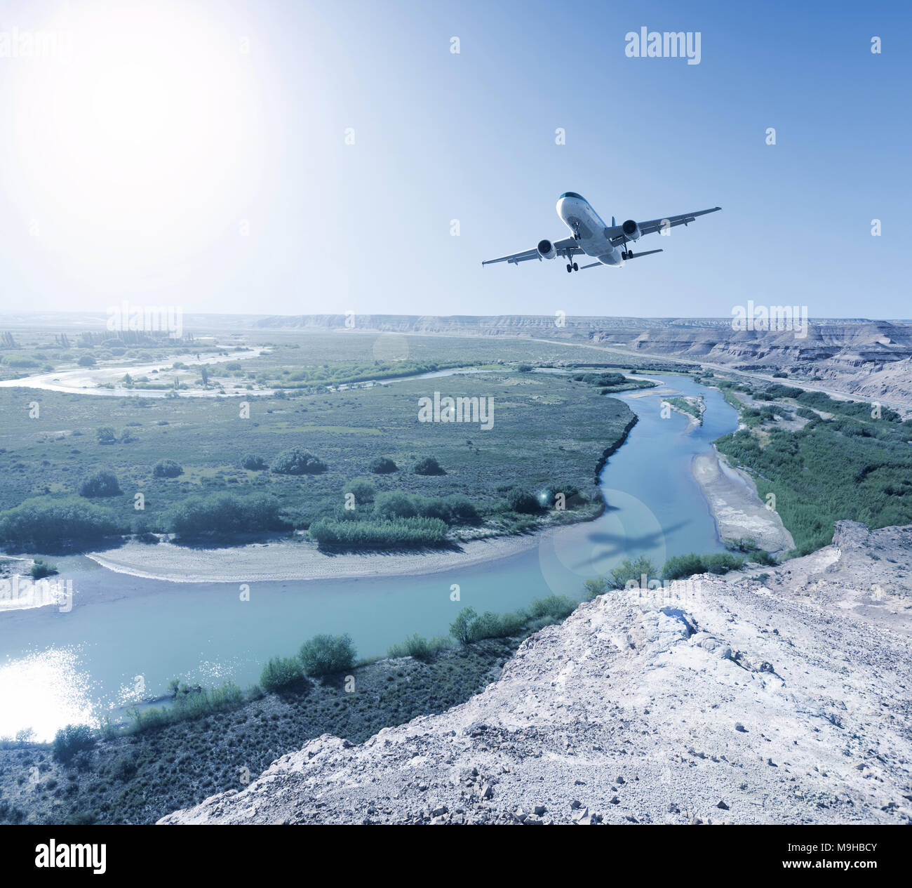 Airplane flying high in the sky above water surface Stock Photo - Alamy