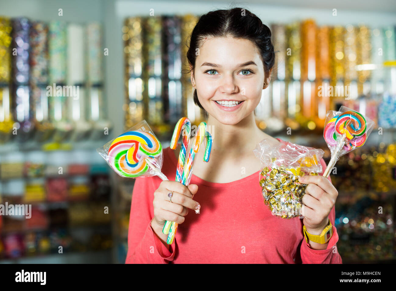 Happy brunette girl buying candies at shop Stock Photo - Alamy