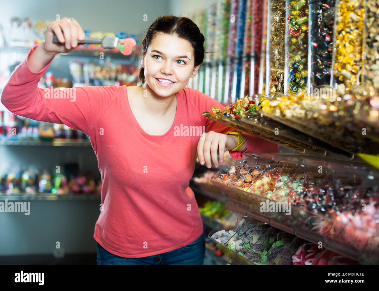 Smiling girl studying assortment of marmalade and bonbons in the ...
