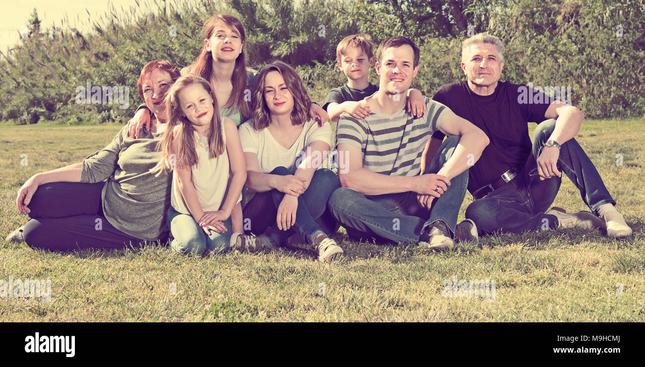 Glad people of different ages taking photos on the lawn Stock Photo - Alamy