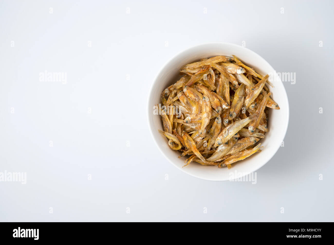 fried small fish in a cup on white background Stock Photo - Alamy