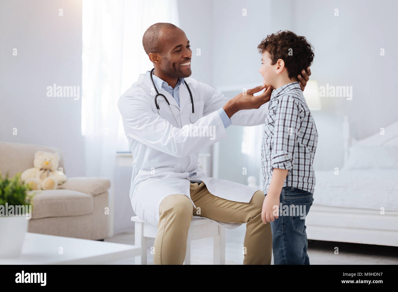 Pleasant male doctor checking boys tonsils Stock Photo - Alamy