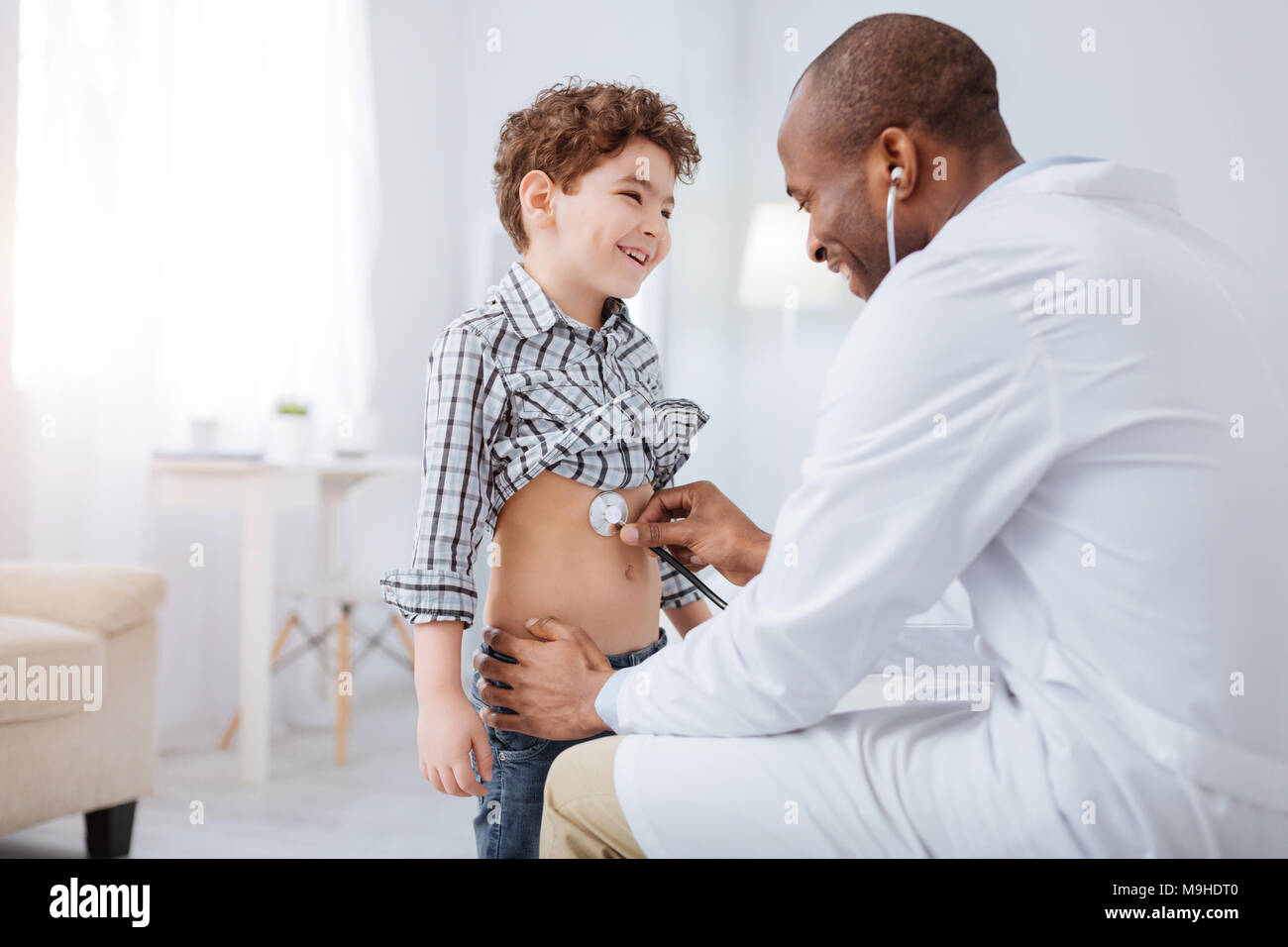 Skillful male doctor hearing boy Stock Photo - Alamy