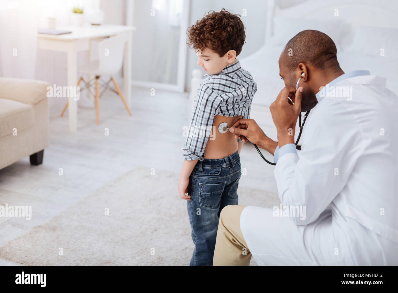 Afro American male doctor using stethoscope Stock Photo - Alamy