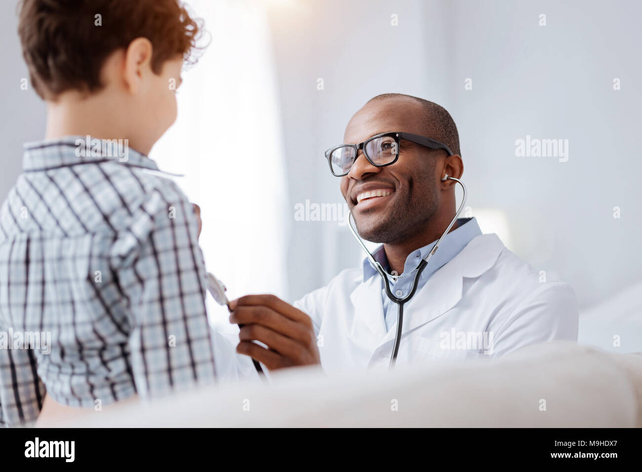Merry male doctor performs boys examination Stock Photo - Alamy
