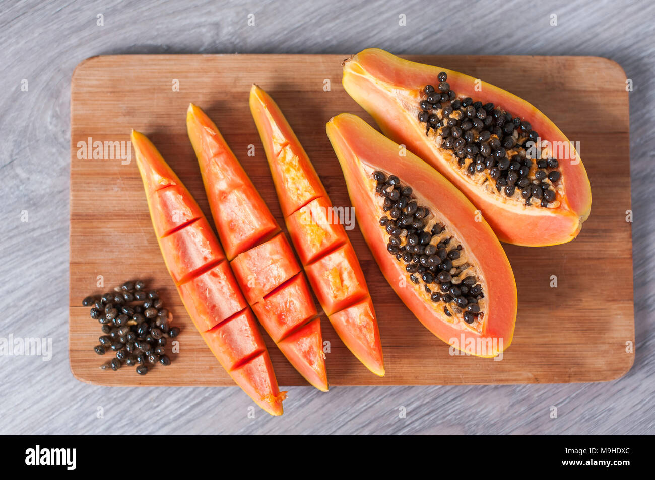 Papaya fruit cut in slices on wooden background Stock Photo - Alamy