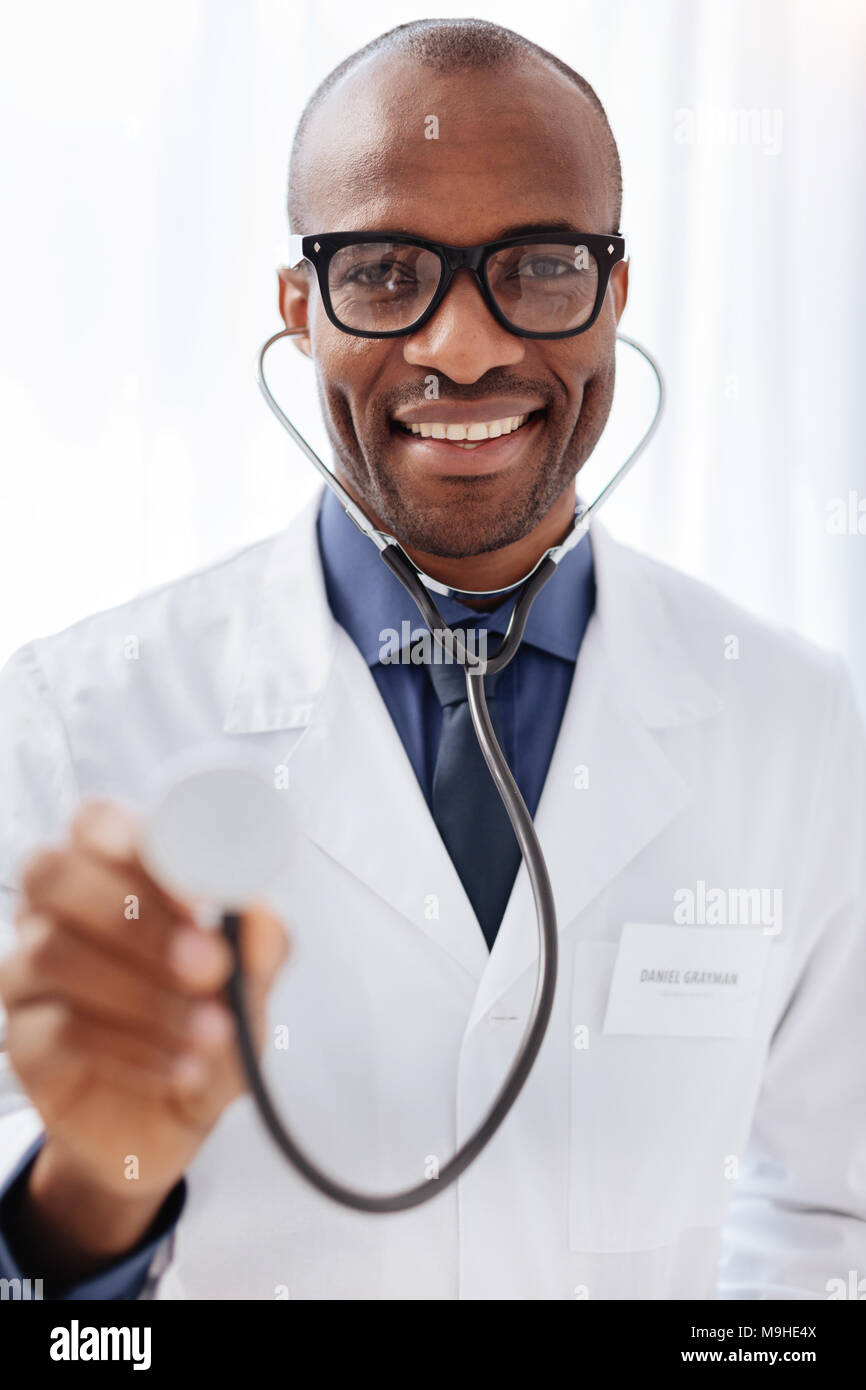 Enthusiastic male doctor demonstrating stethoscope Stock Photo - Alamy