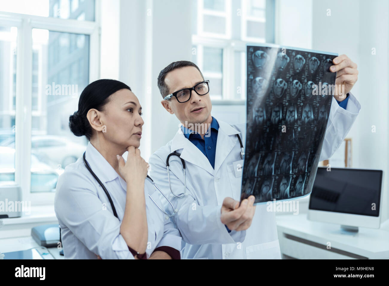 Concentrated doctors looking at mri scan Stock Photo - Alamy