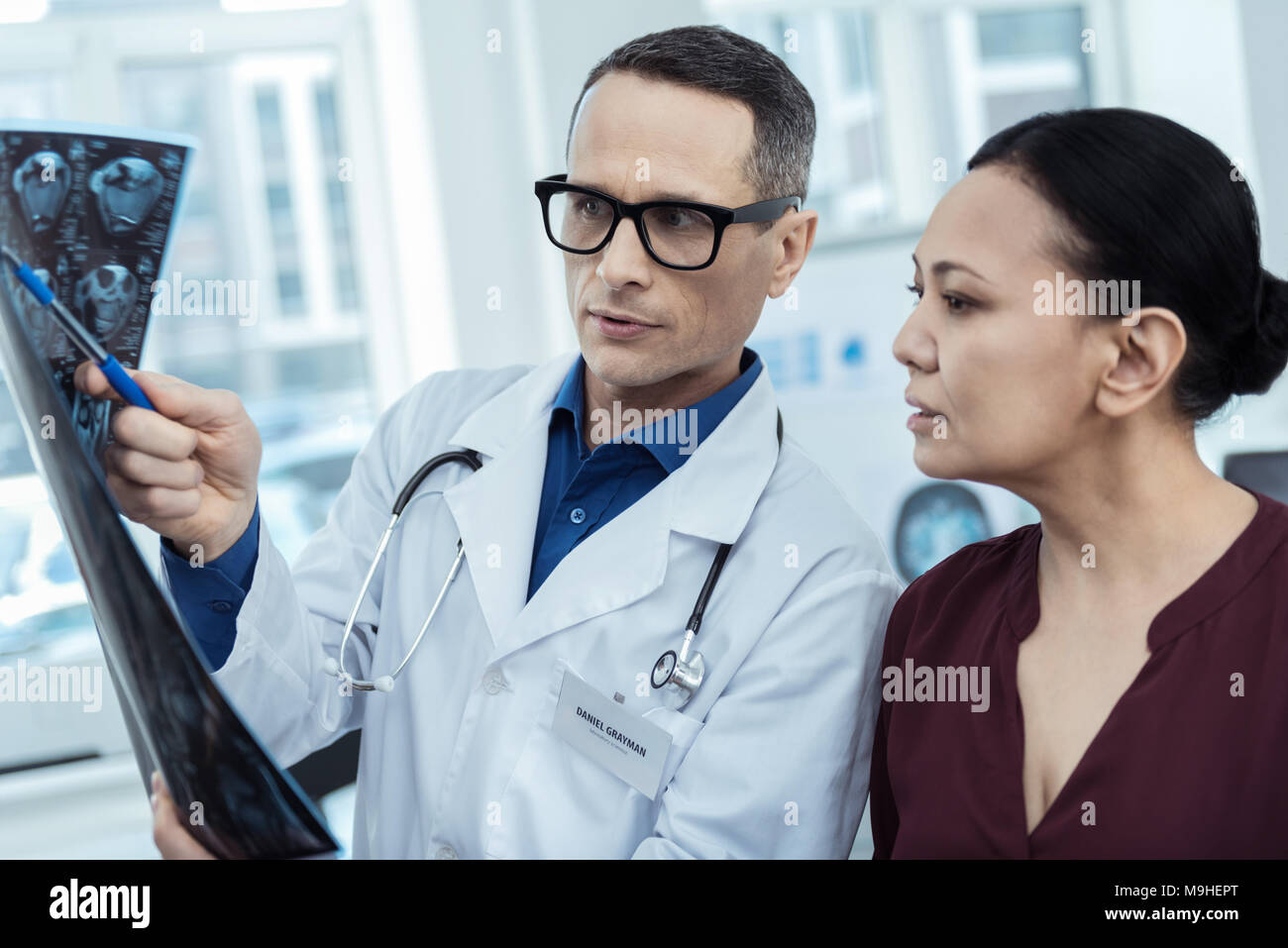 Concentrated doctor showing a brain scan too his patient Stock Photo ...