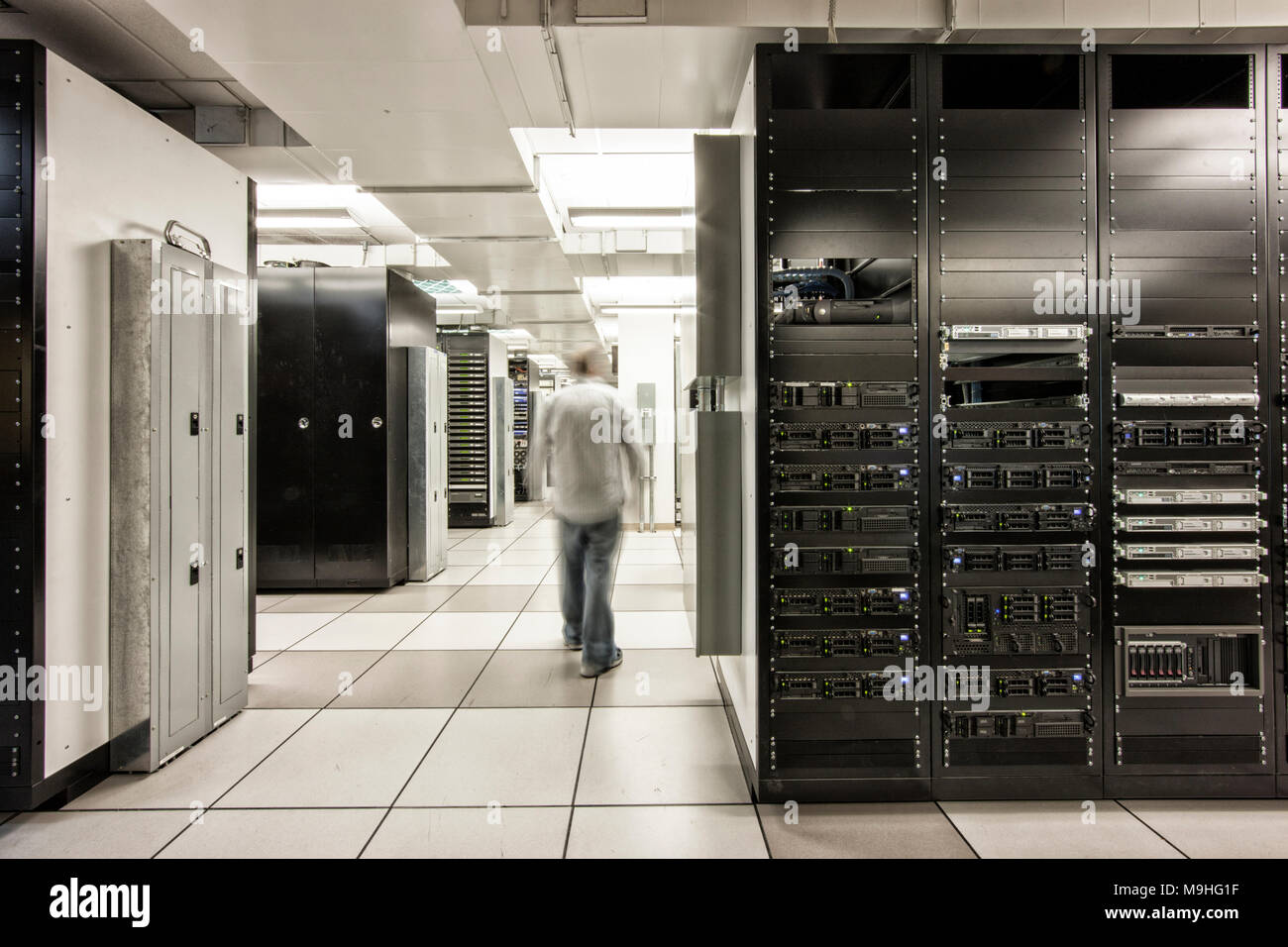 Computer server room racks with technician in background Stock Photo ...