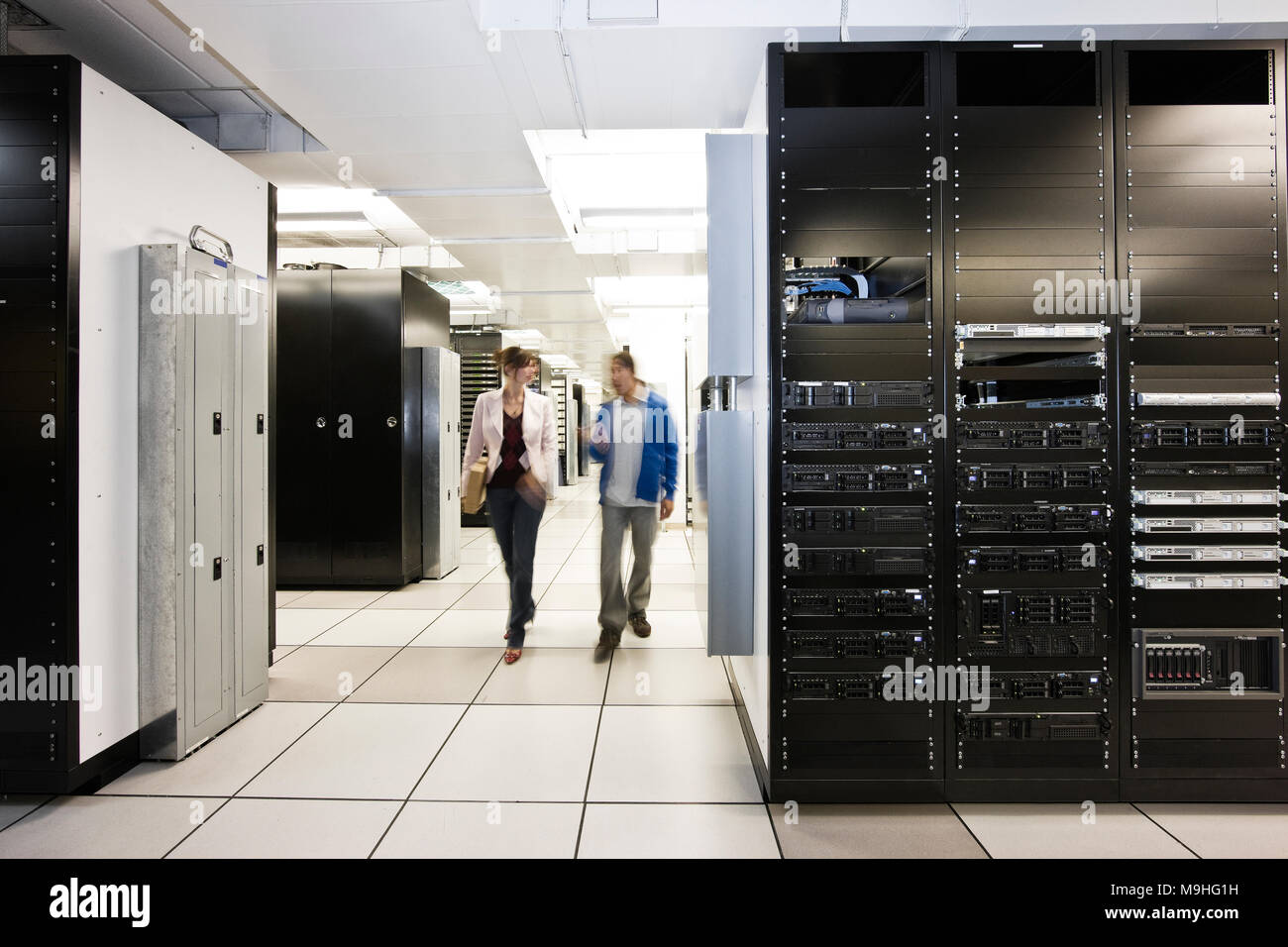 Computer server room racks with technician in background Stock Photo ...