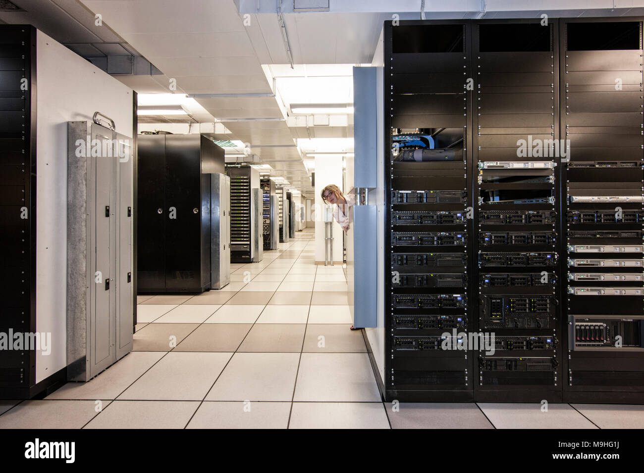 Computer server room racks with technician in background Stock Photo ...