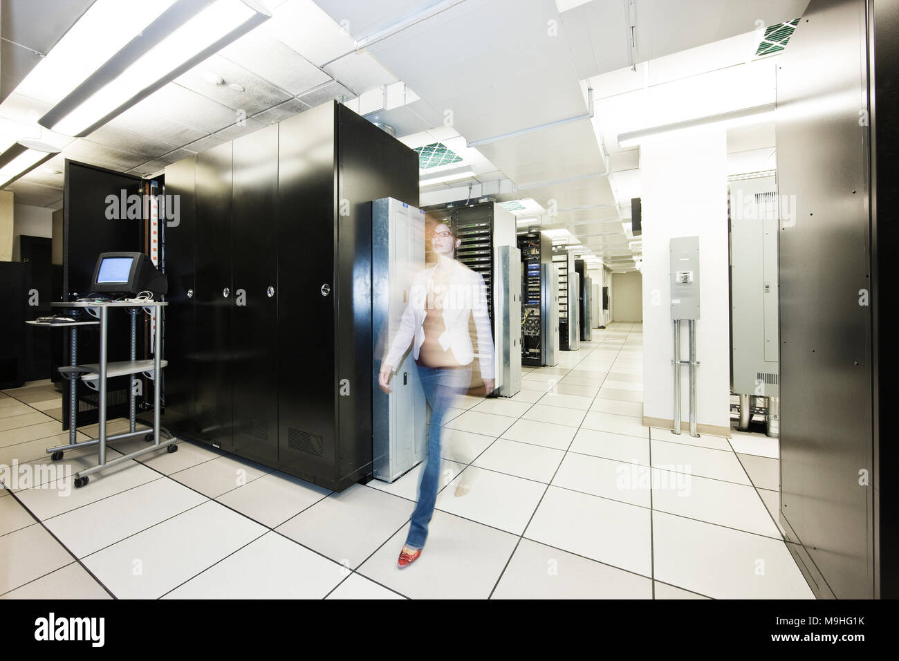 Computer server room racks with technician in background Stock Photo ...