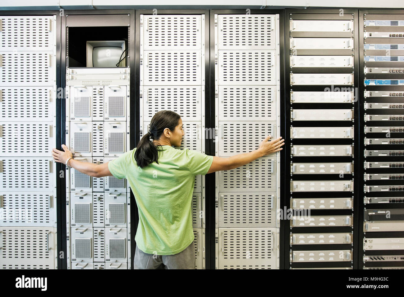 Computer technician working in a large computer server room Stock Photo ...