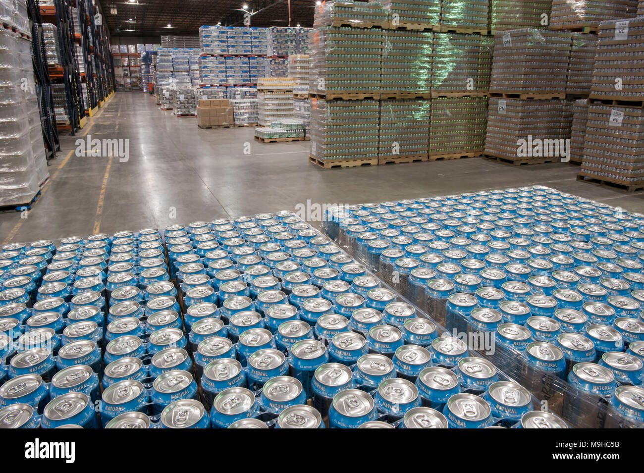 Cans of flavored water stored in the warehouse of a large bottling ...