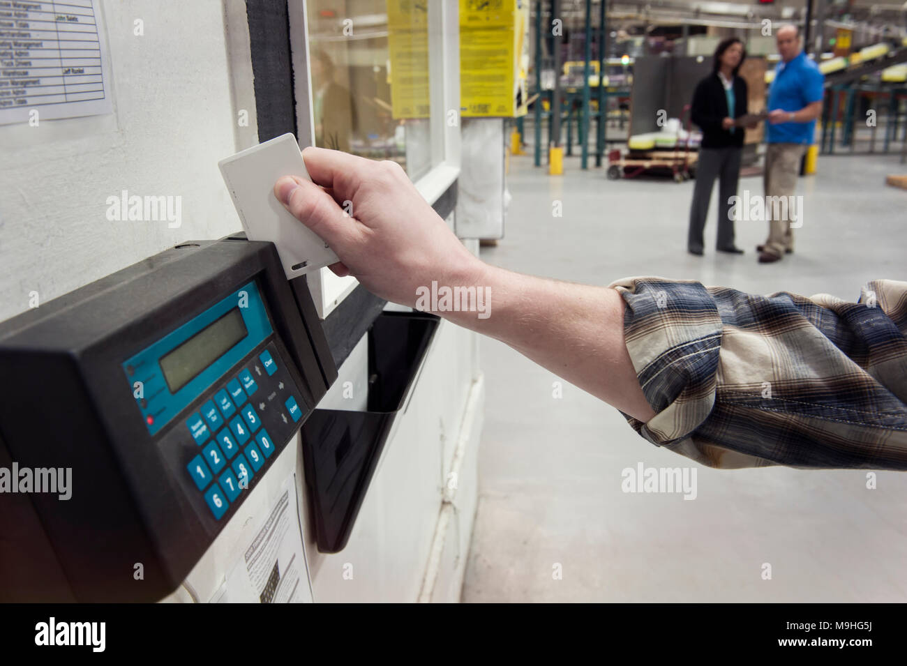 Close up of a hand checking in for work in a warehouse using a card key ...