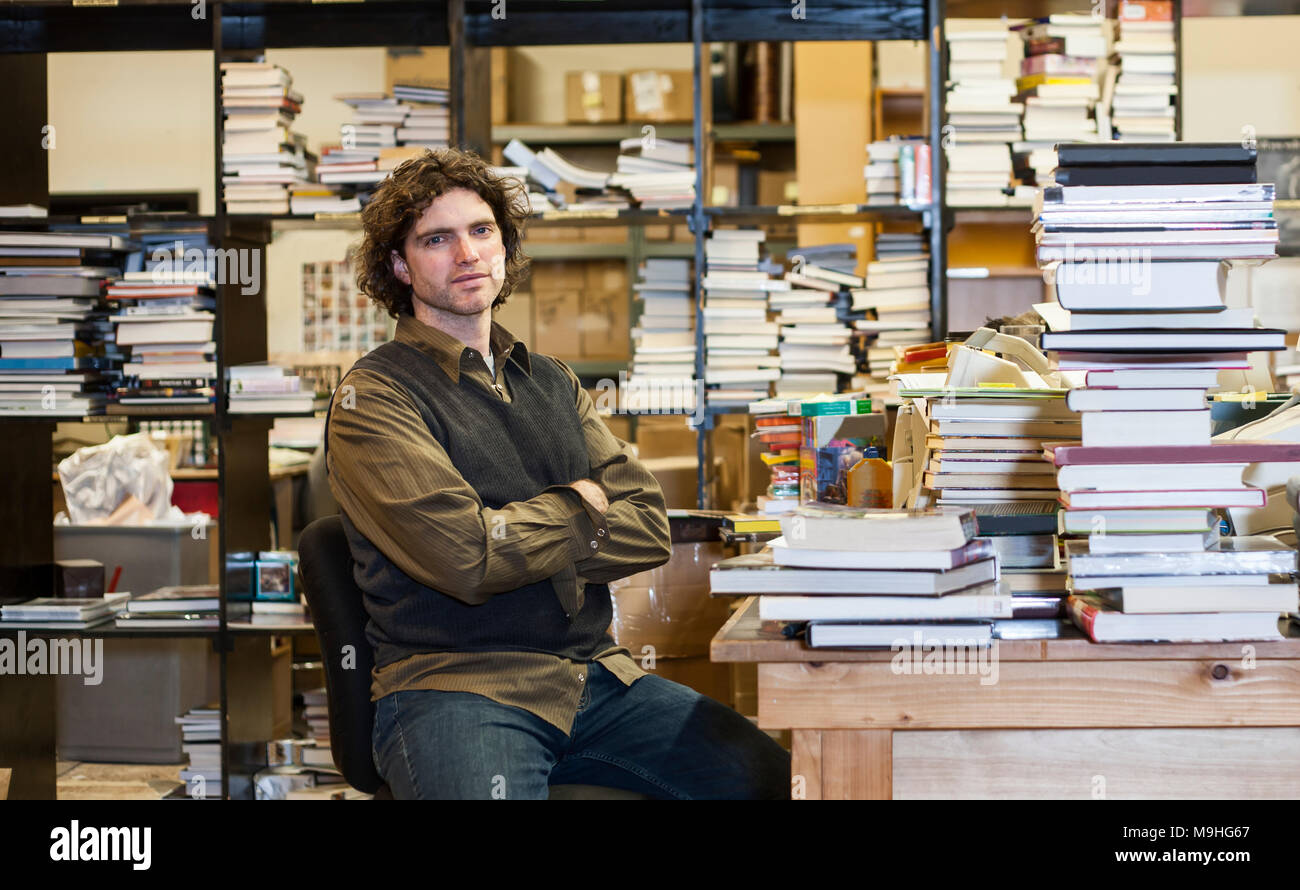 Portrait of a caucasian male employee of a bookstore working in the ...