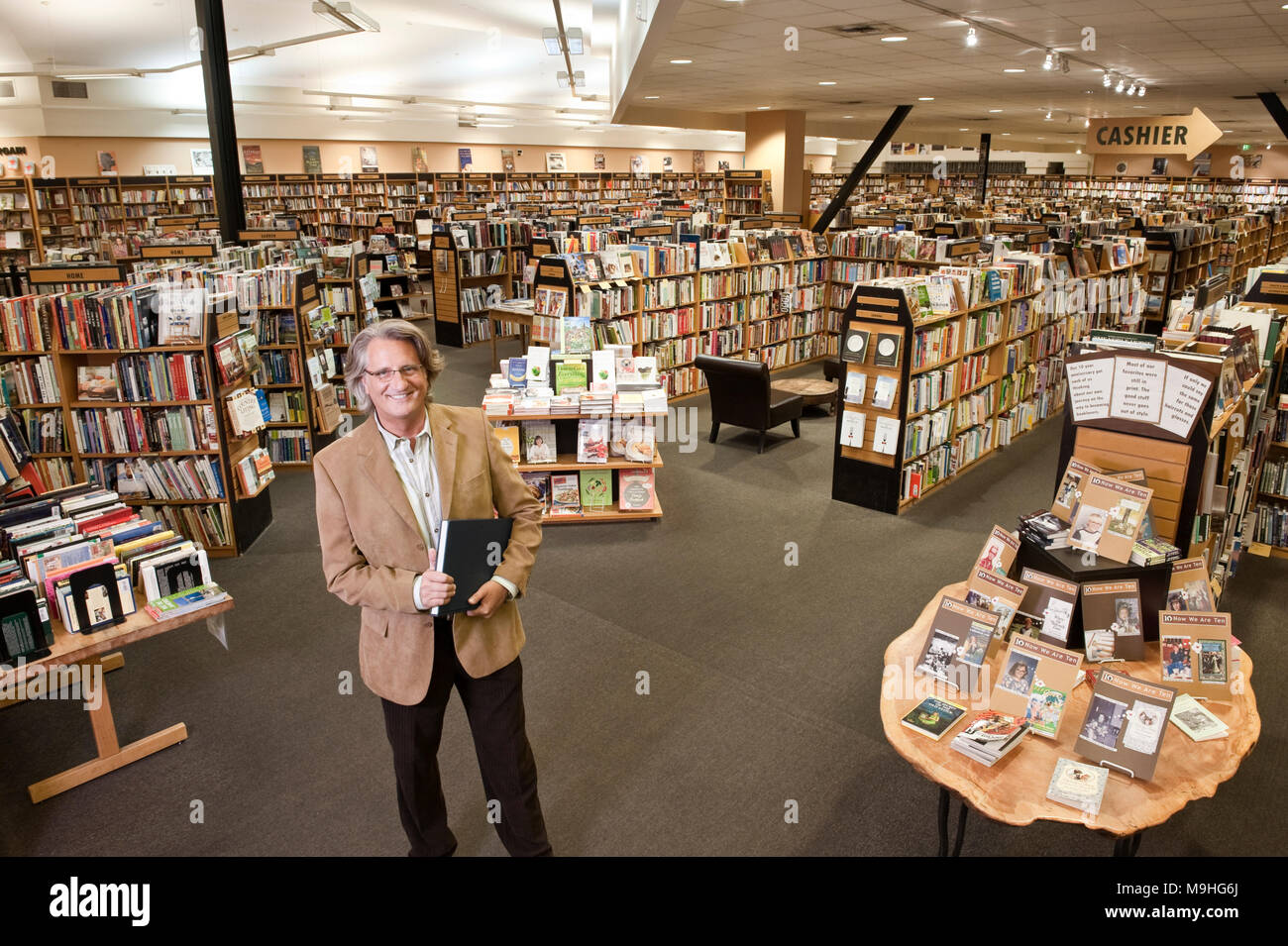 Portrait of a caucasian male owner of a large bookstore, showing ...