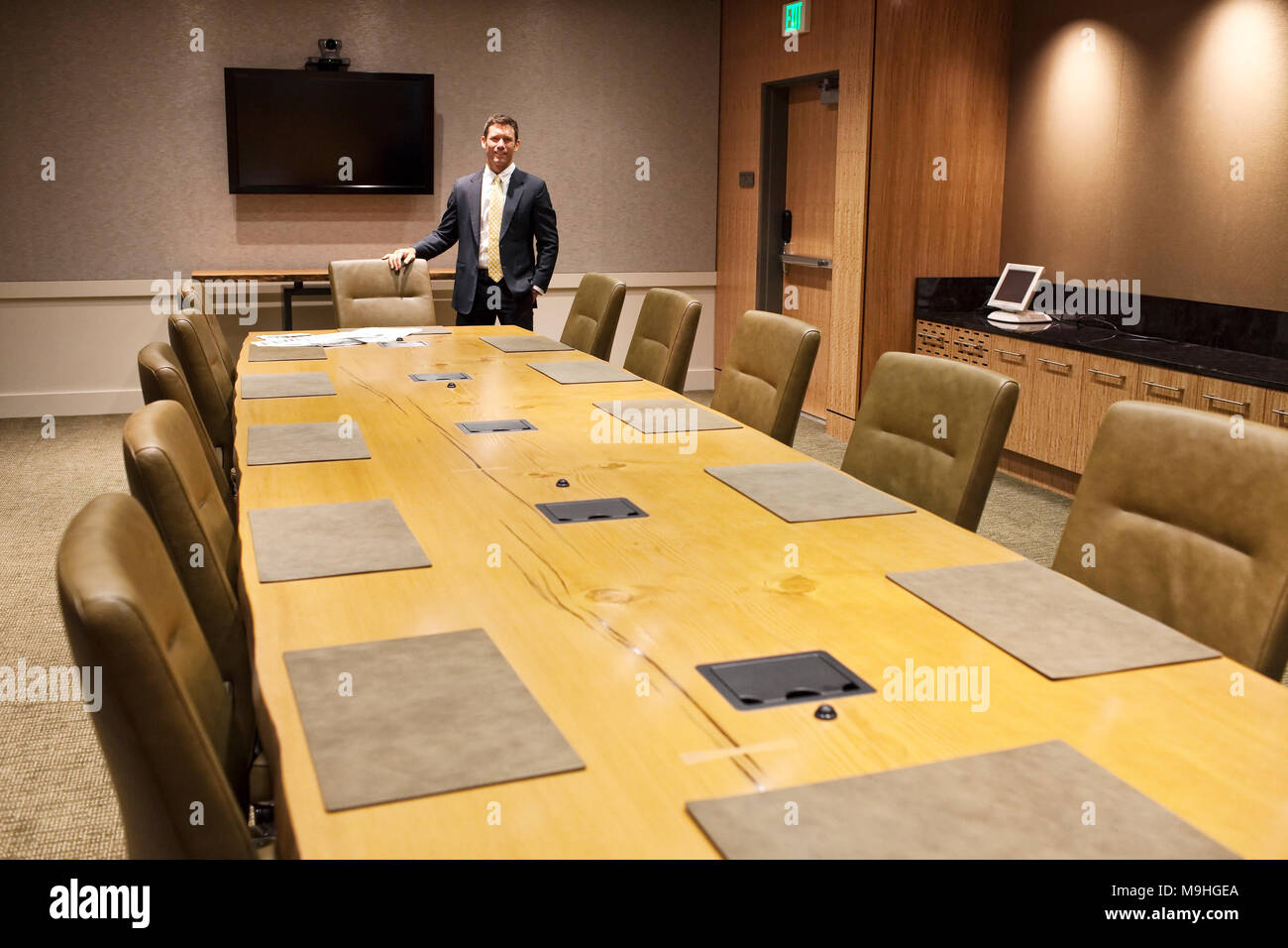 Businessman at the head of a large conference room table Stock Photo ...