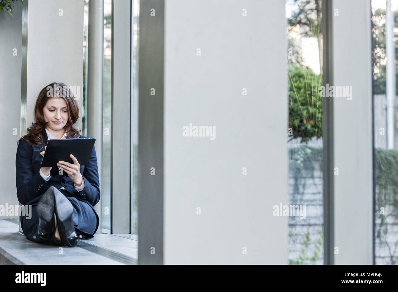 Woman sitting on ledge window hi-res stock photography and images - Alamy