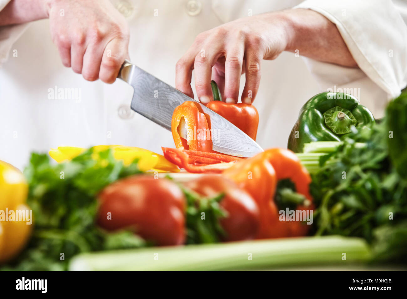 Close-up of a chef using a knife to chop fresh produce, colourful ...