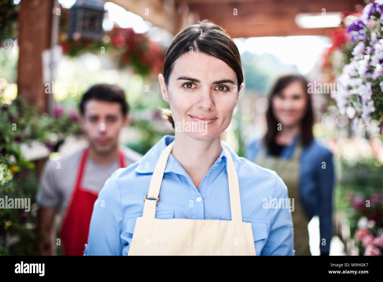 Staff of a garden center nursery with a caucasian woman employee in the ...