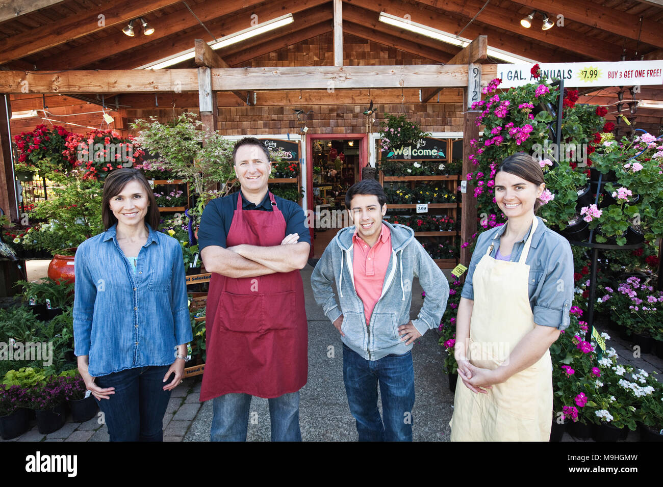 Plant nursery store owners and employees standing in a row in front the ...