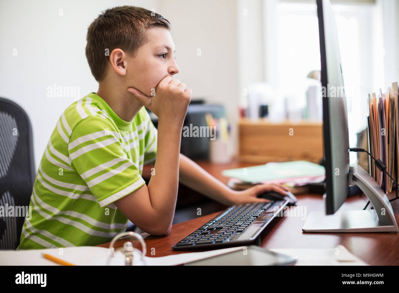 Young caucaasian boy at work on a desk top computer system Stock Photo ...
