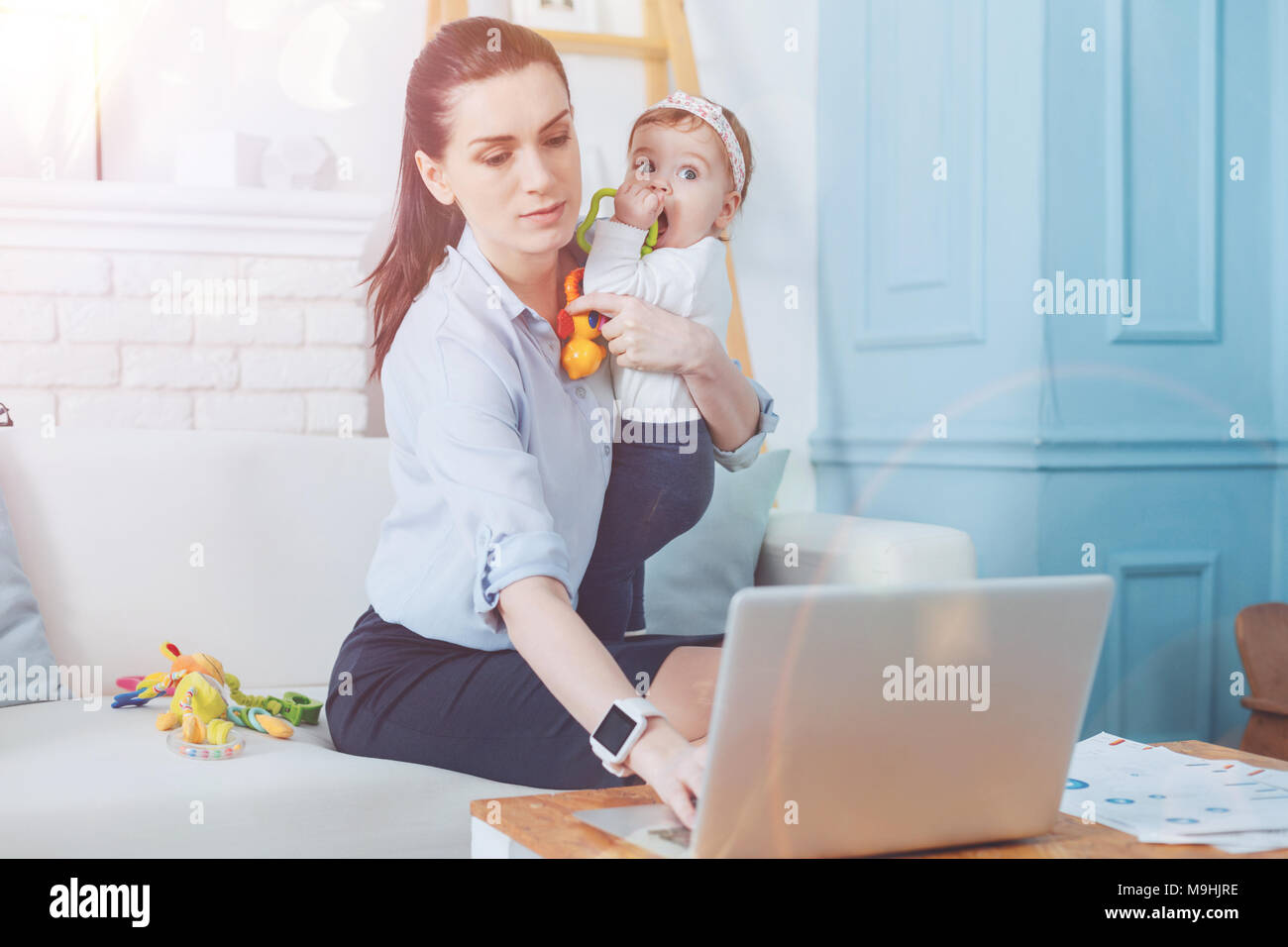 Nice smart woman looking after her daughter Stock Photo - Alamy