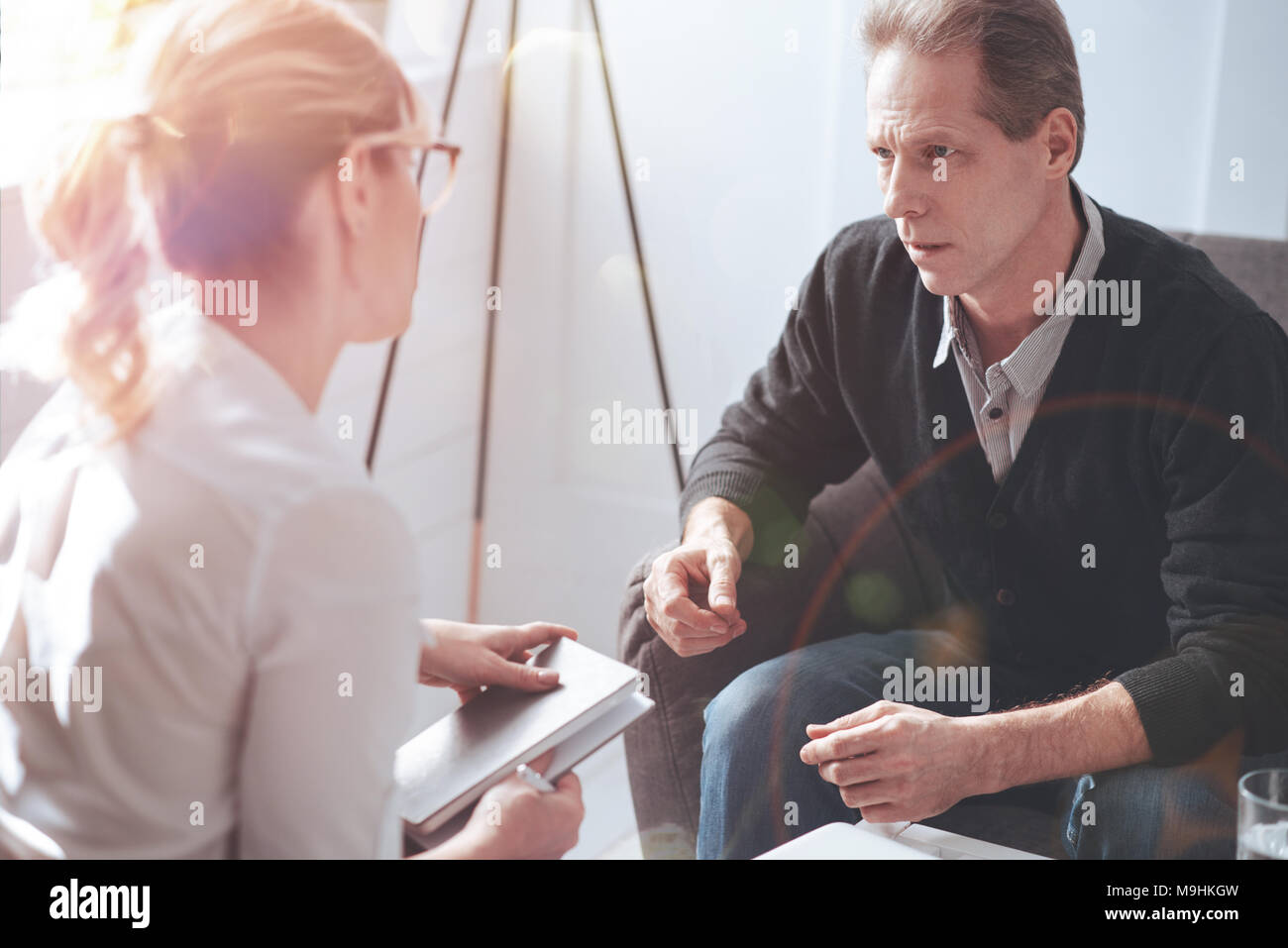 Sad moody man sitting on the sofa Stock Photo - Alamy