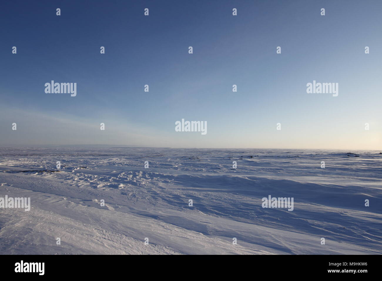 White winter arctic landscape with blowing snow on the ground a blue ...