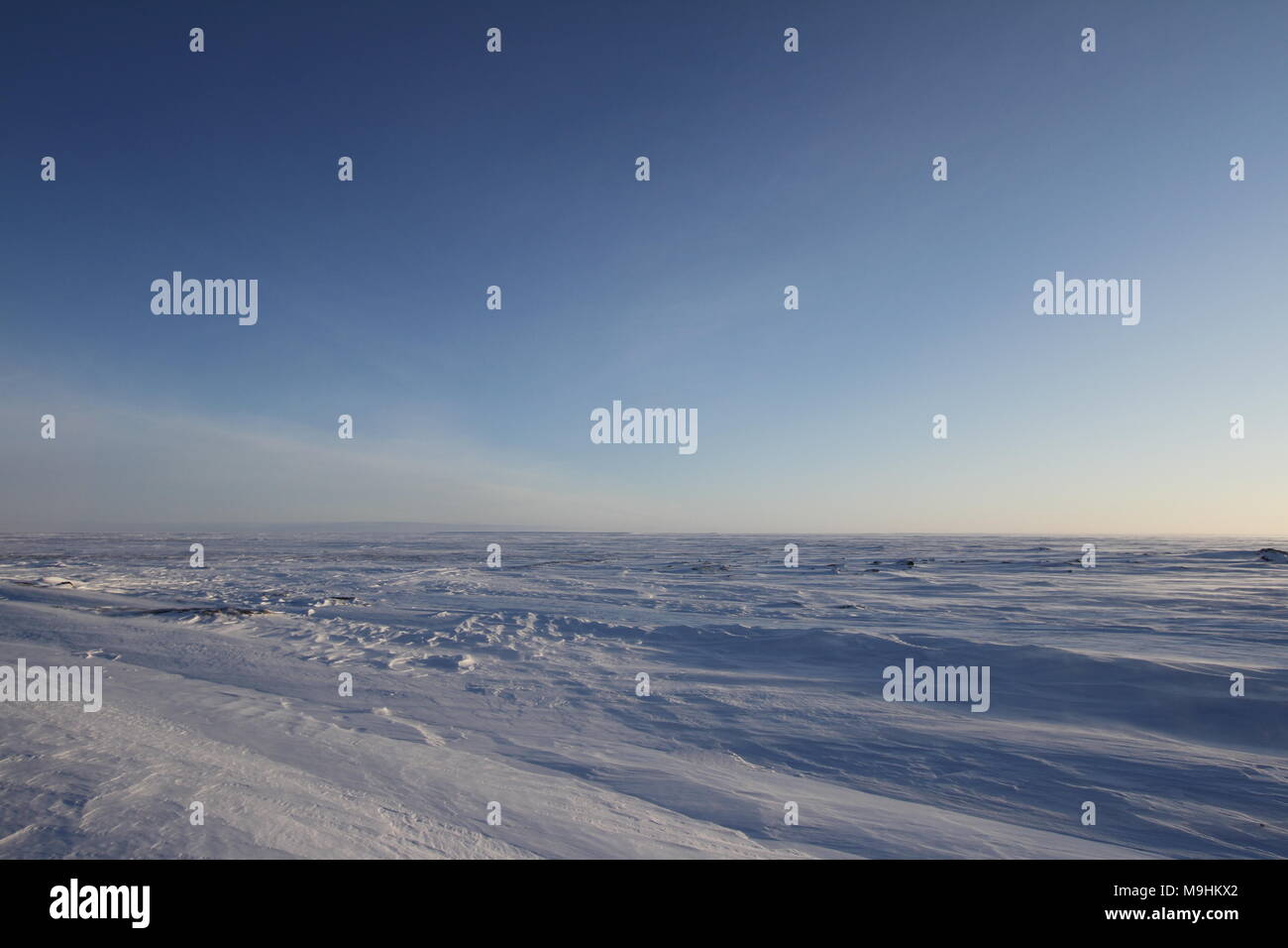 White winter arctic landscape with blowing snow on the ground a blue ...
