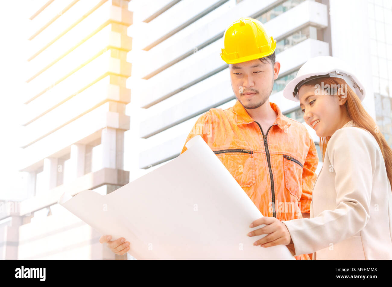 engineer and foreman looking at constructed paper blueprint plans at ...