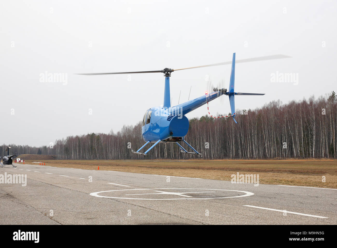 The aircraft - rear view the blue small helicopter makes flight at low ...