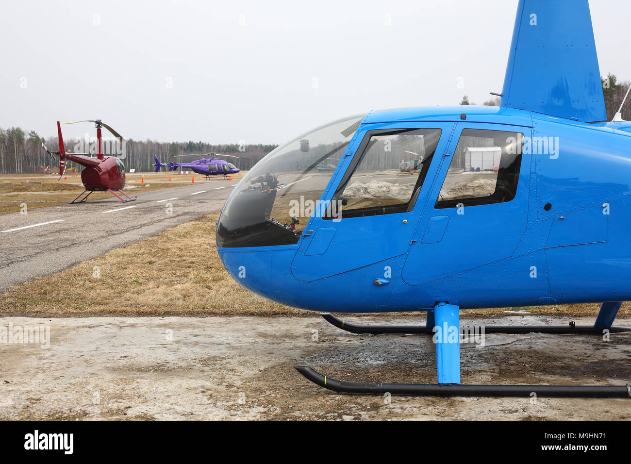 Aircraft - Several small helicopters on the parking a forest background ...