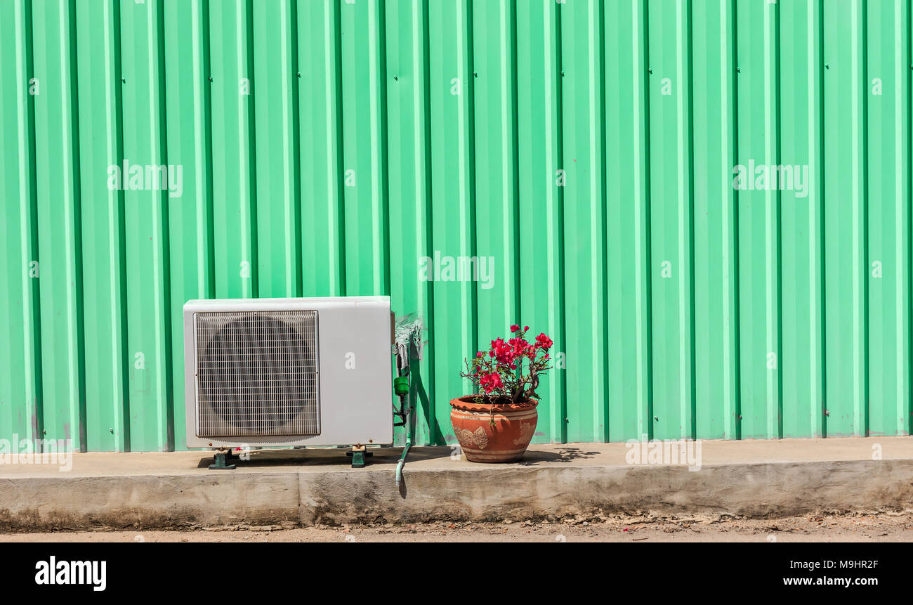Old compressor air-conditioner and Flower Pot on green zinc wall Stock ...
