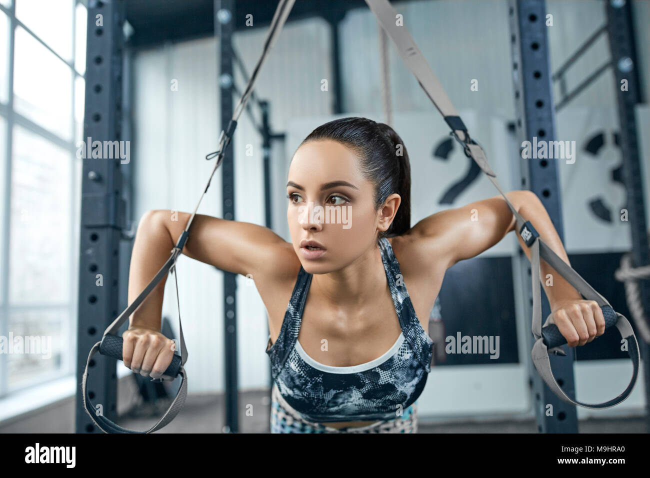 Young woman exercises in gym healthy lifestyle pulling weights Stock ...