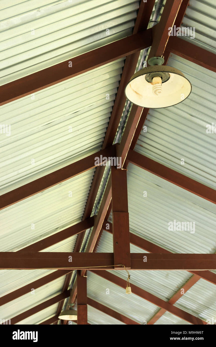 Metal net lamp hanging under zinc roof Stock Photo - Alamy