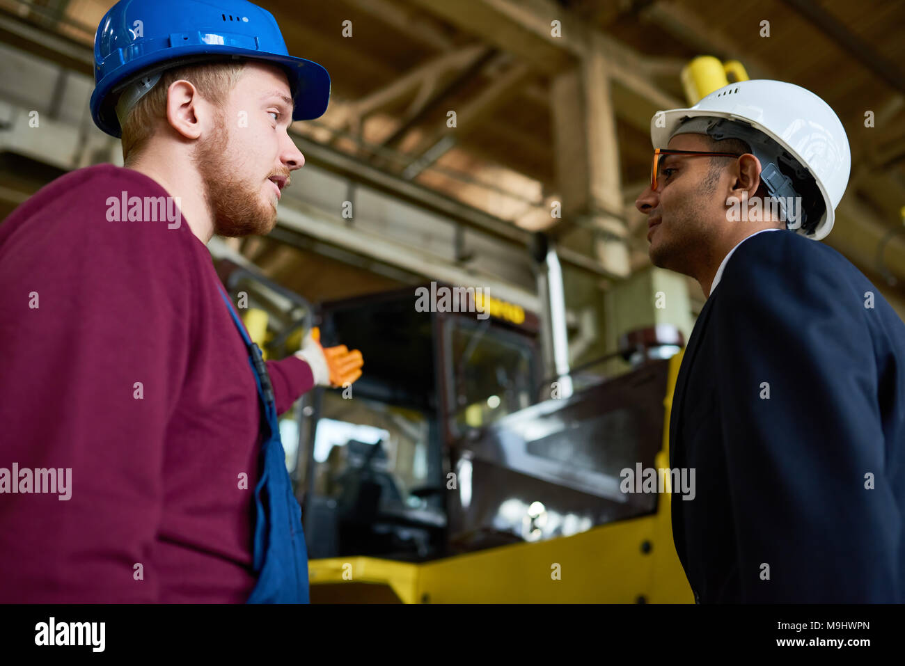 Engineers Discussing Heavy Machinery at Plant Stock Photo - Alamy