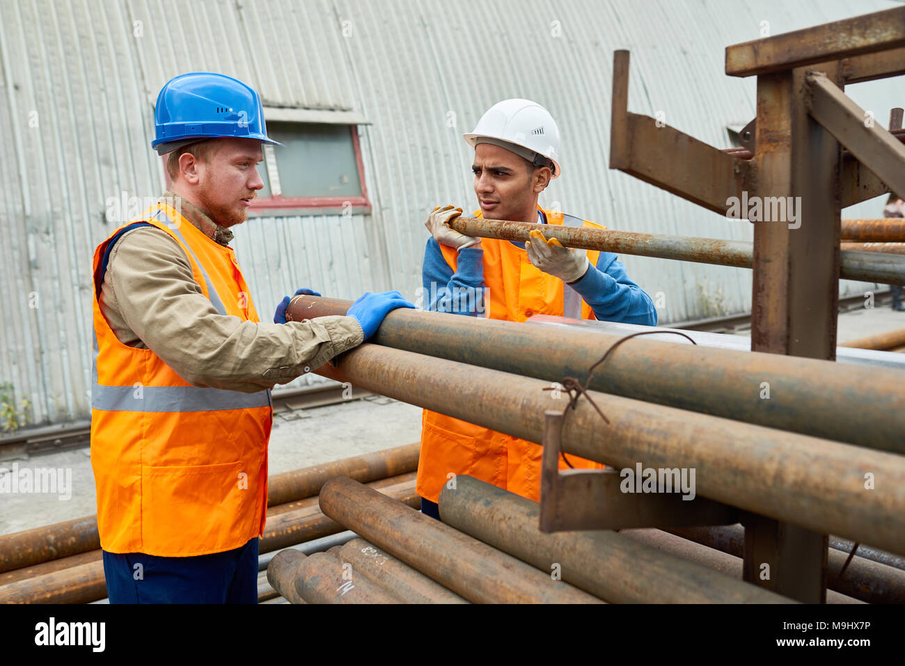Workers Moving Pipes Stock Photo - Alamy