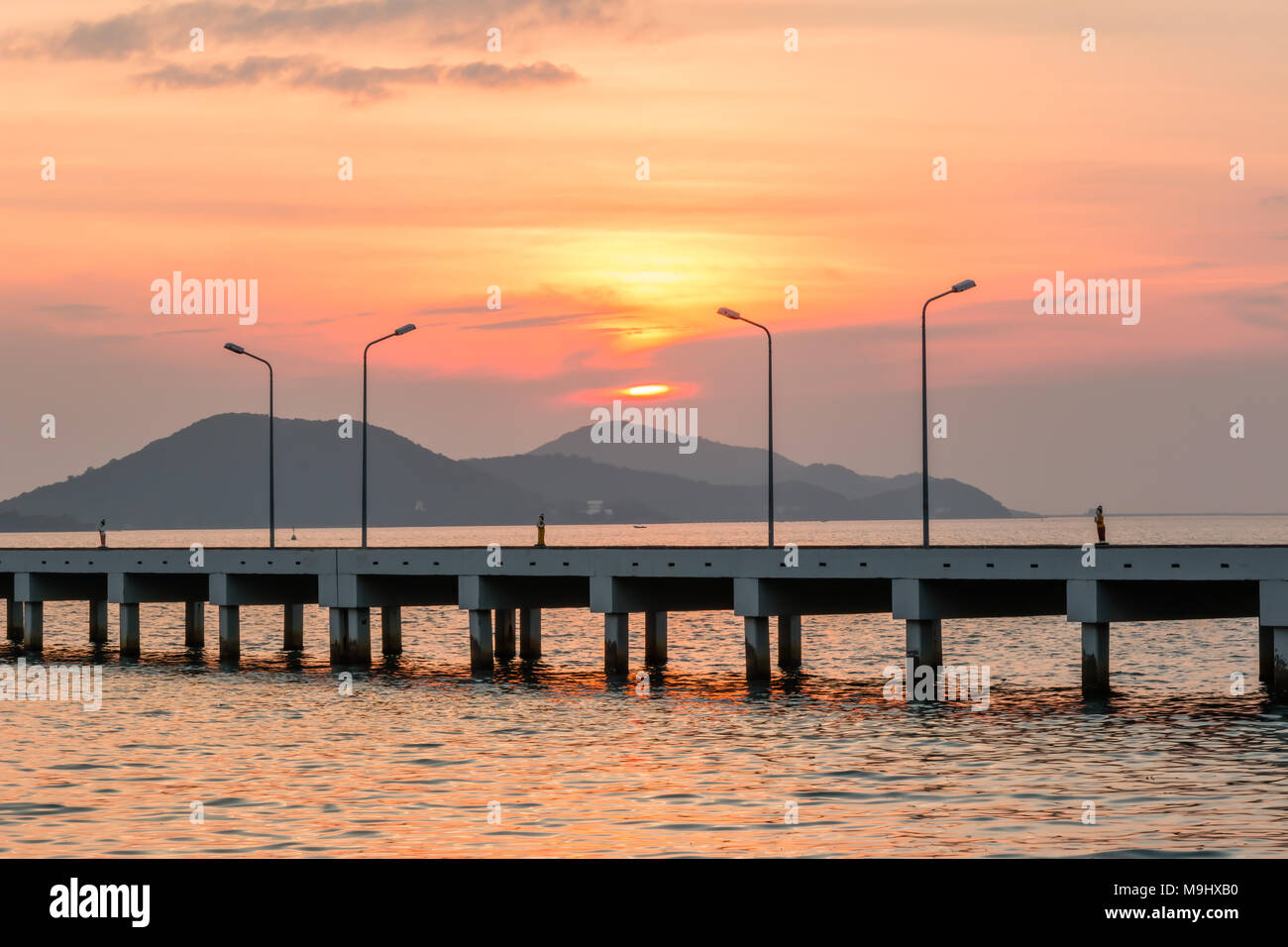 Sunset behind Small port ship and lamp post Stock Photo - Alamy