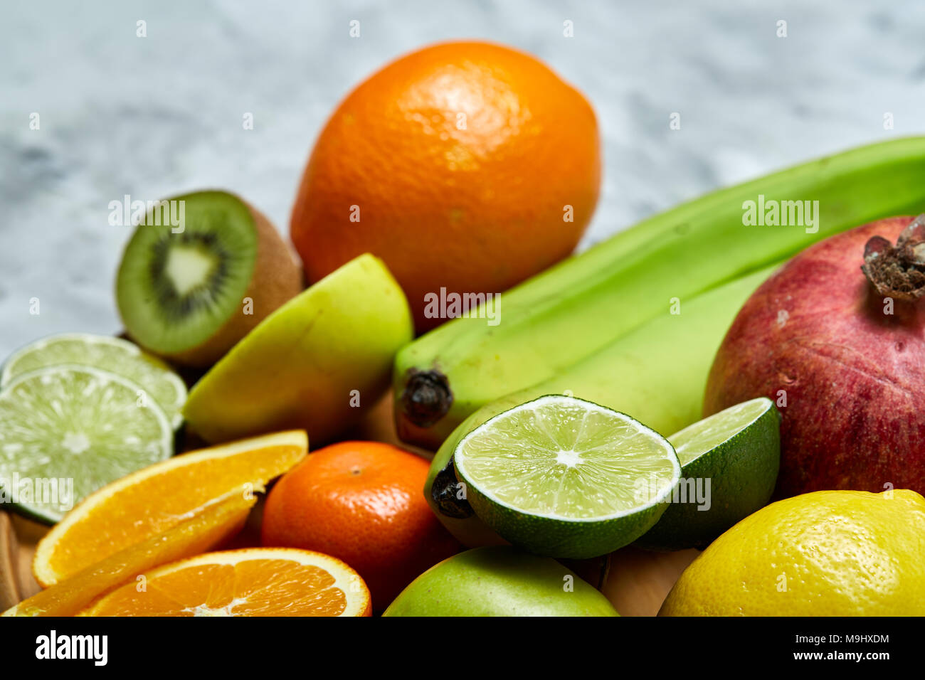 Ripe fresh fruits in a wooden plate on a light background, selective ...
