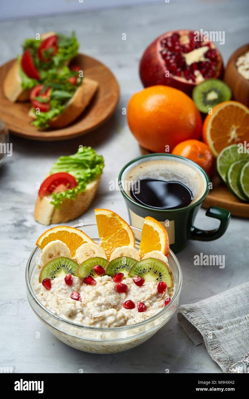 Breakfast still life with oatmeal porridge, fruits, coffee cup served ...