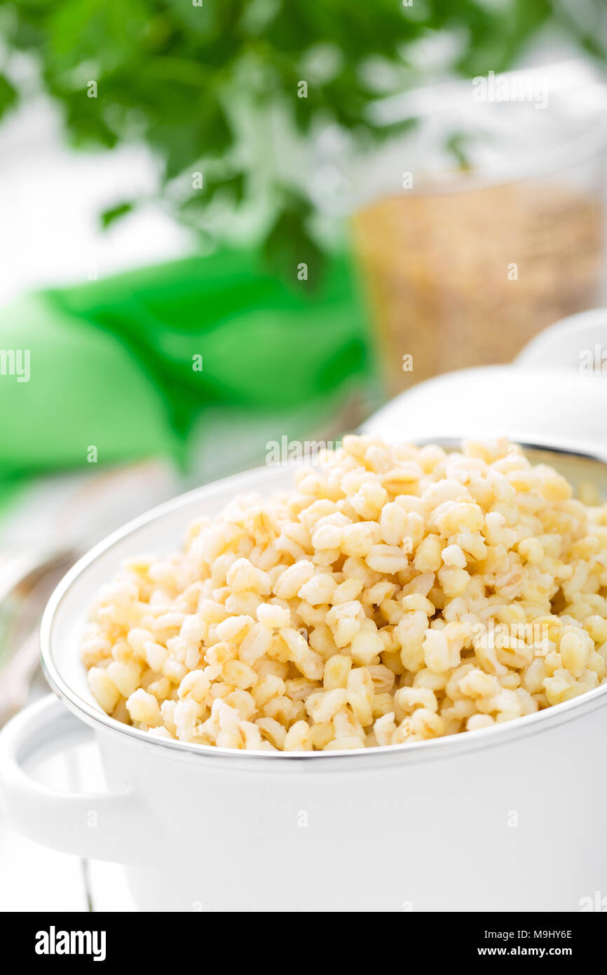 Bulgur wheat. Boiled bulgur cereal in pot on white kitchen table ...