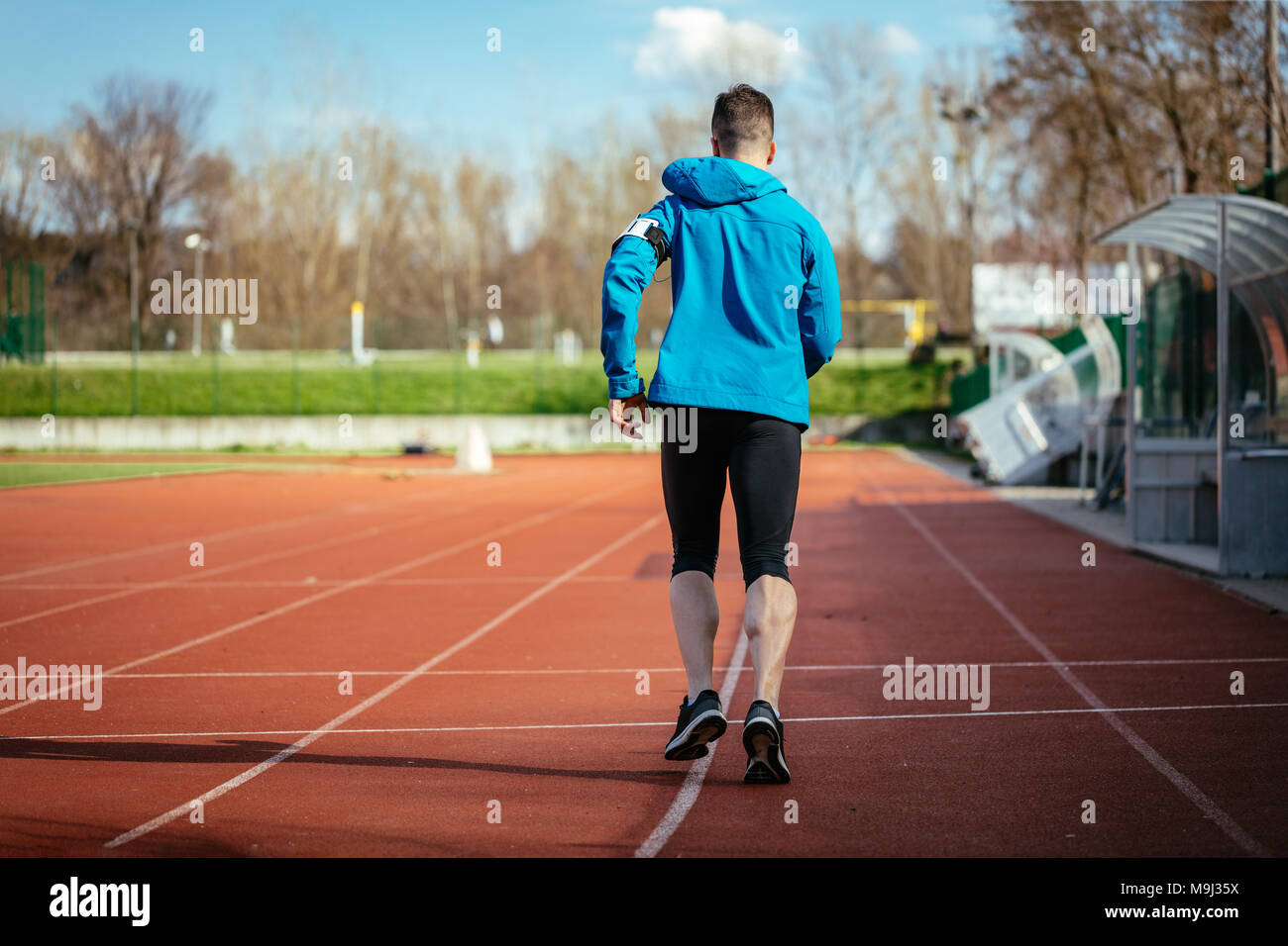 Rear view of athletic fit young sport man in full body length on tartan ...