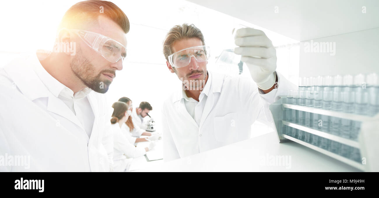 closeup. scientist and assistant studying the solution in the gl Stock ...