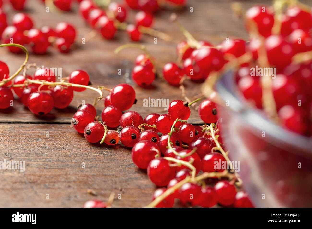 Red currant is scattered on a wooden background, space for text Stock ...