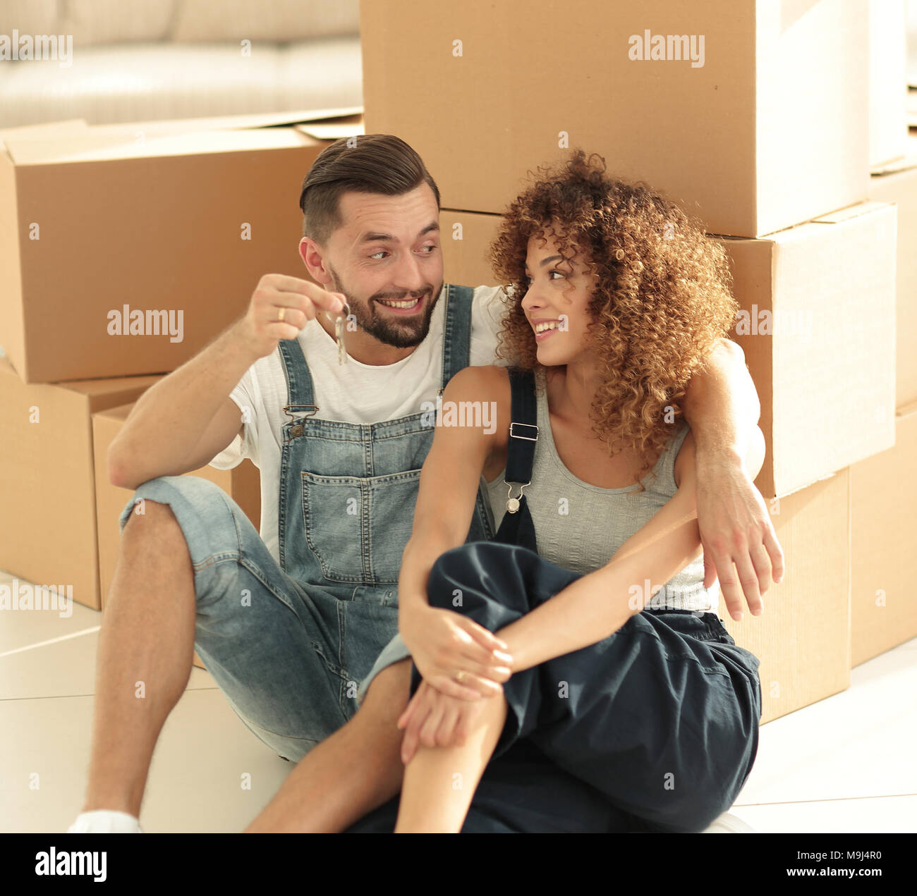 Happy new tenants sitting near cardboard boxes Stock Photo - Alamy