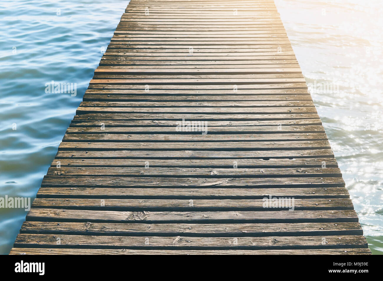 wooden pier path over water with waves on a sunny summer day Stock ...